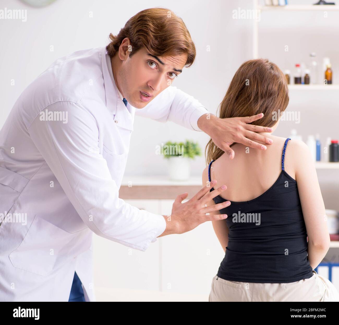 The female patient visiting young handsome doctor chiropractor Stock ...