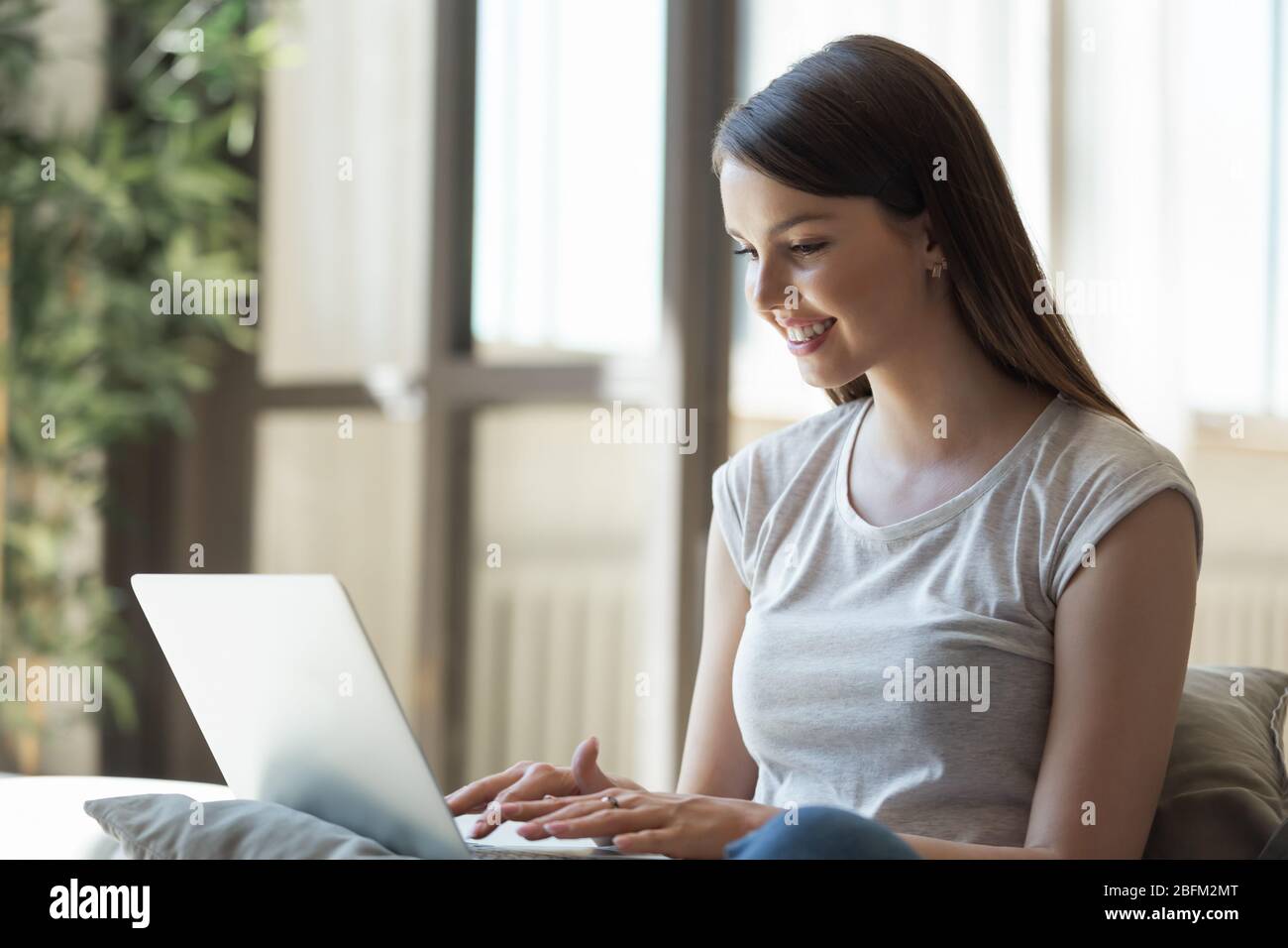 Close up smiling woman using laptop checking email good news Stock Photo - Alamy
