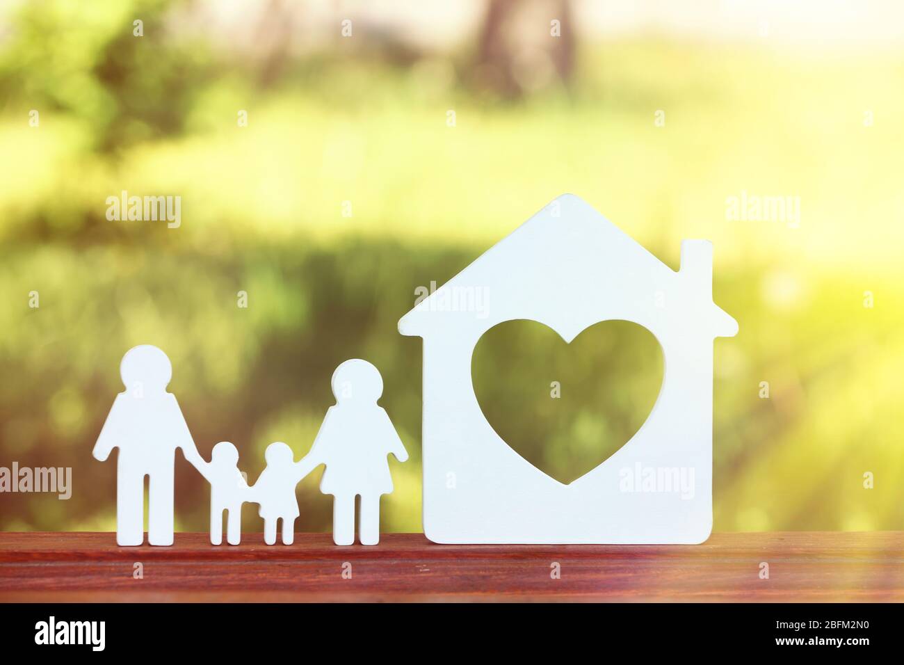 Small model of house and family on blurred background Stock Photo - Alamy