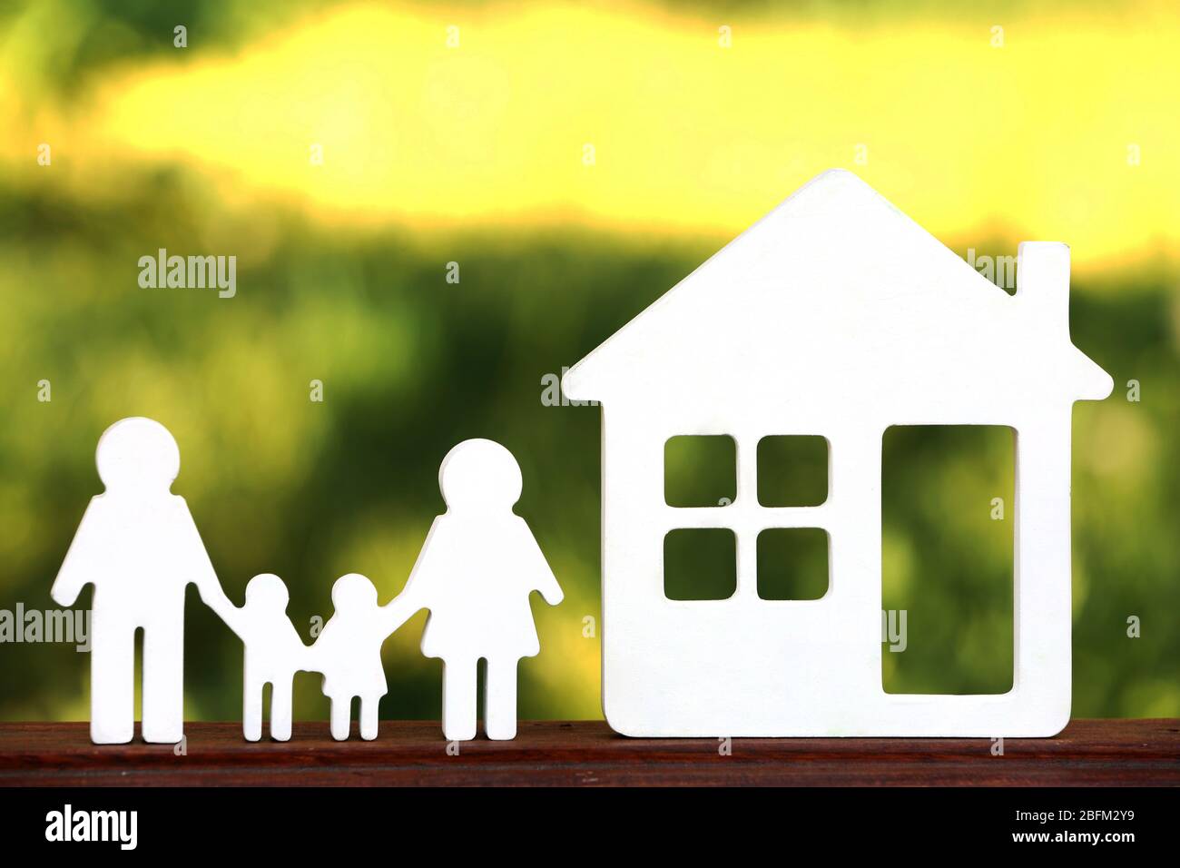 Small model of house and family on blurred background Stock Photo - Alamy