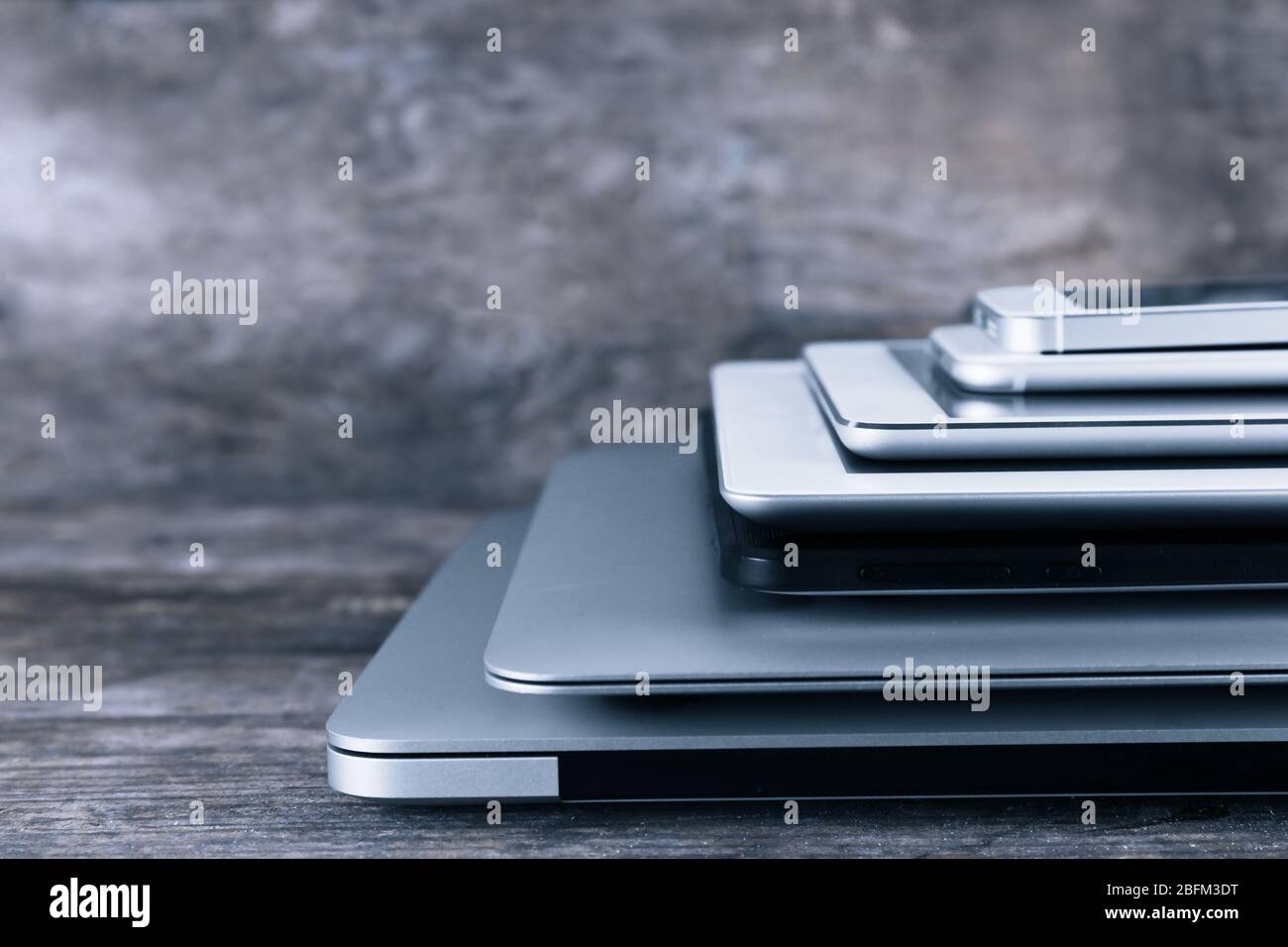 Pile of different modern electronics gadgets on old wooden background ...