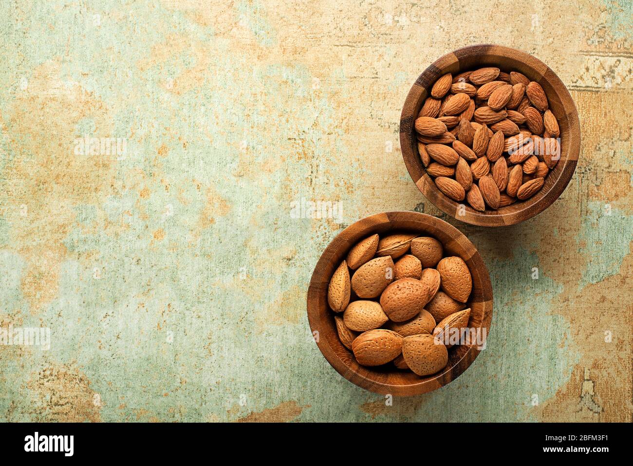 Fresh raw Almonds fruit in shell and shelled in wooden bowl. Almond ...