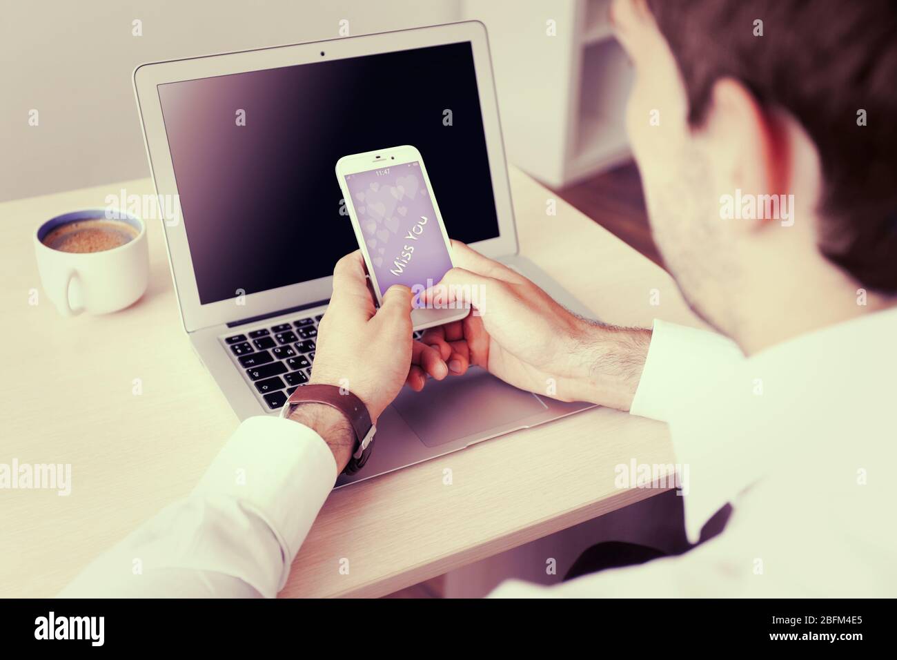 Man using mobile phone with romantic screensaver in office Stock Photo ...