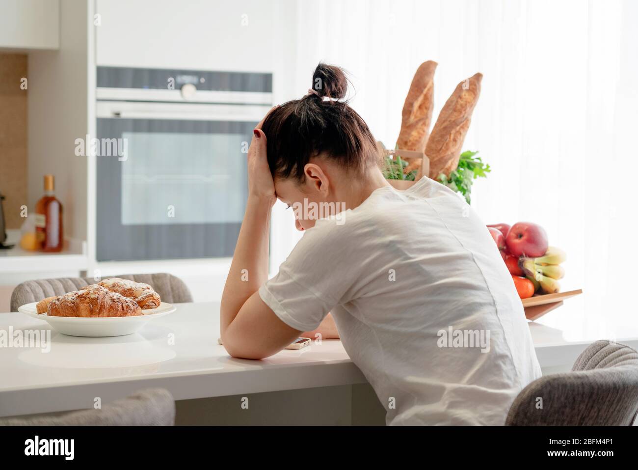 Sad woman kitchen table hi-res stock photography and images - Alamy