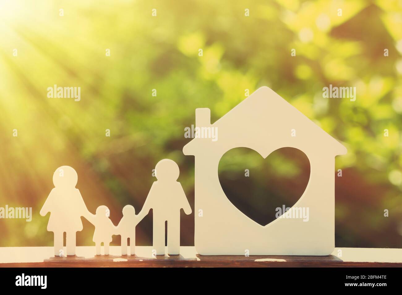 Small model of house and family on nature background Stock Photo - Alamy