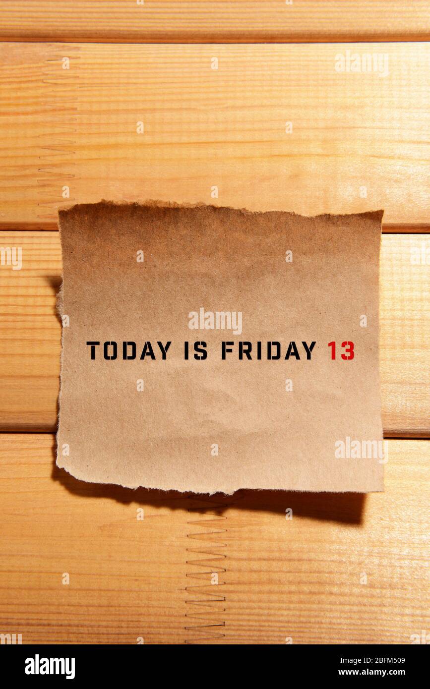 Paper sheet with text Today is Friday 13 on it on wooden background ...