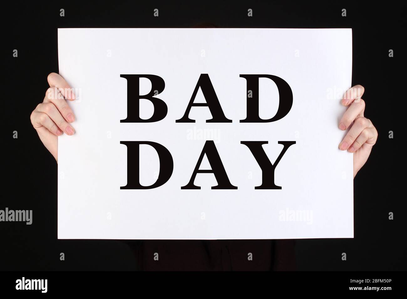 Woman holding poster with text Bad Day in front of her face isolated on ...