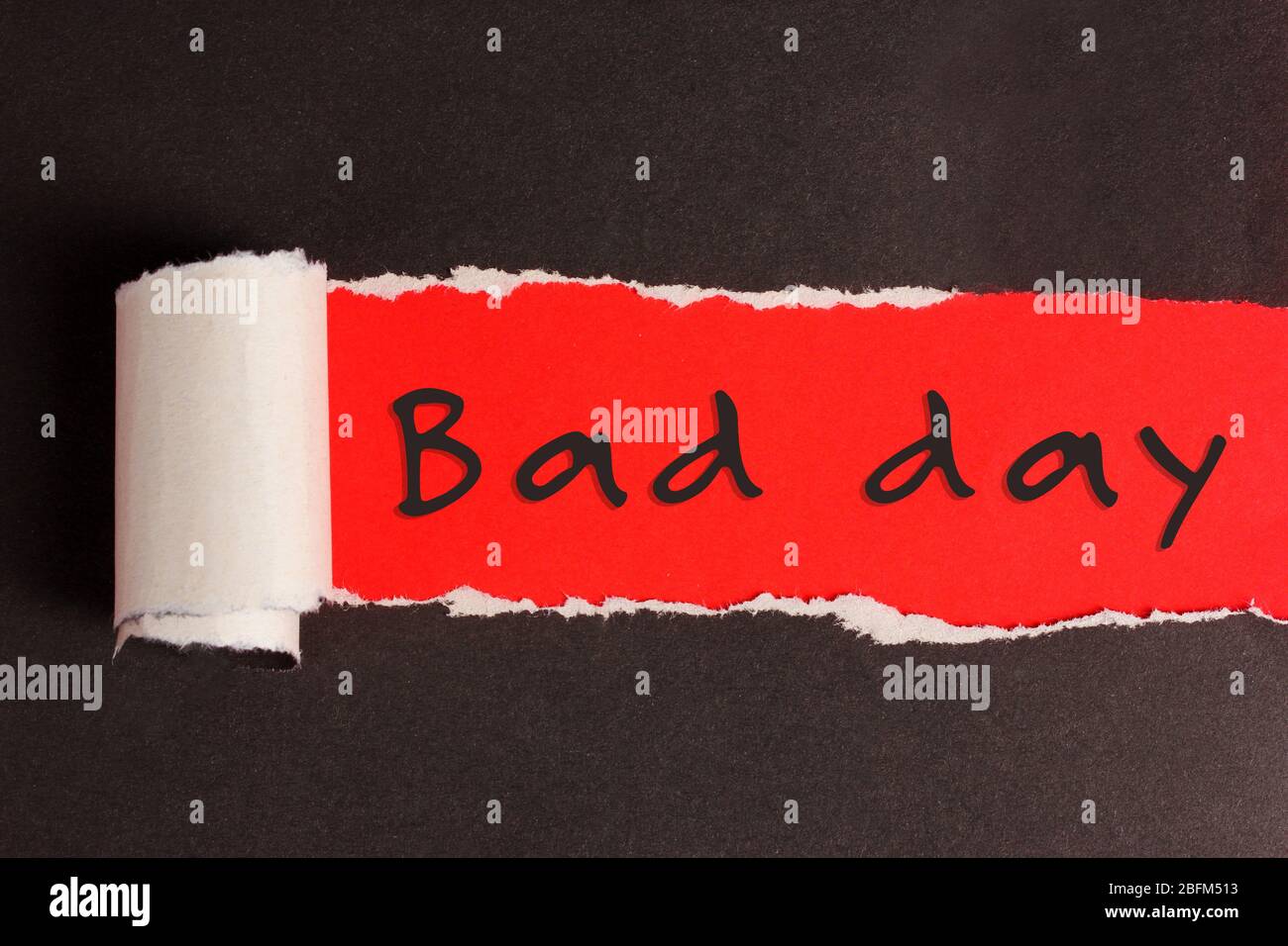 Torn black paper with red background and text Bad day Stock Photo - Alamy
