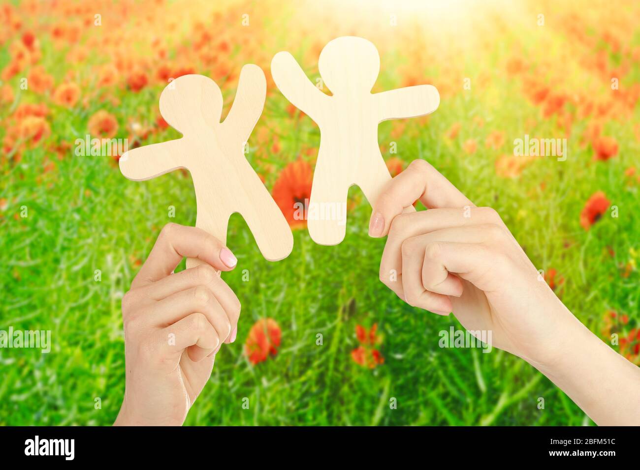 Hands with wooden mens on green nature background. Friendship, ecology ...