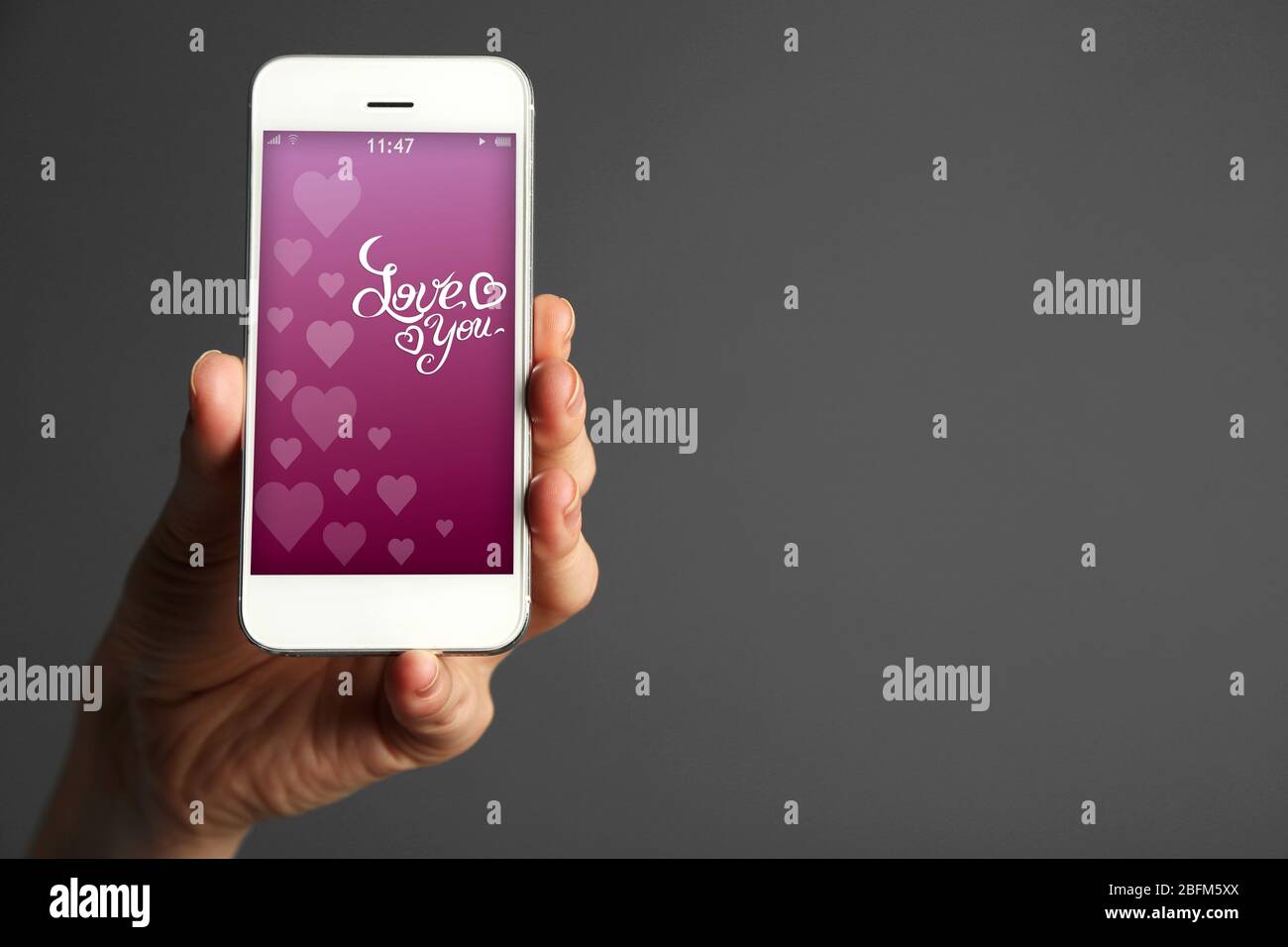Hand holding smart phone with romantic screensaver Stock Photo - Alamy