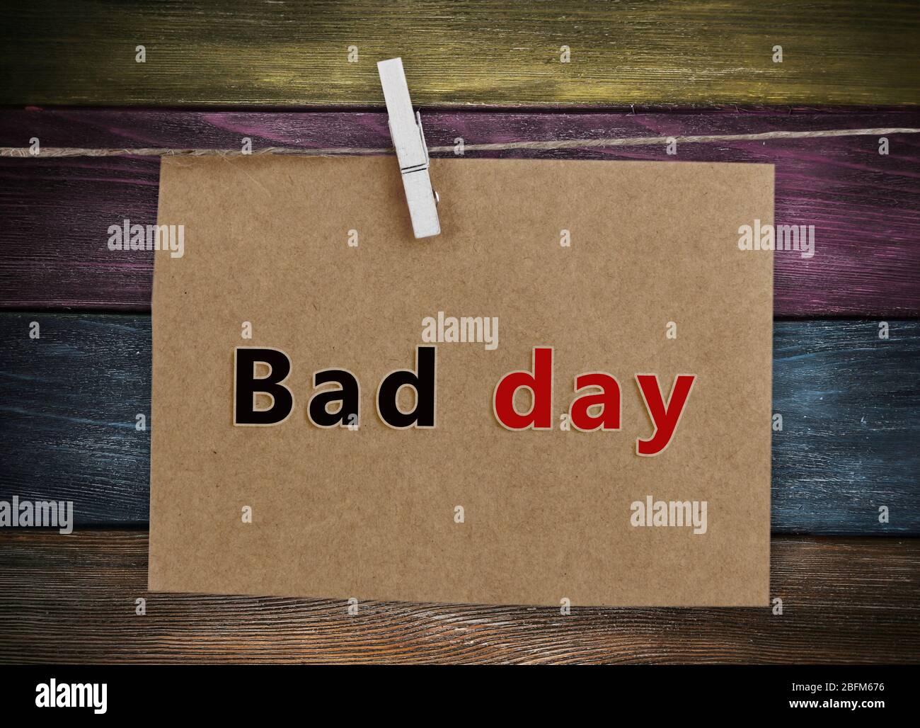Old sheet of paper with text Bad Day hanging on rope isolated on white ...