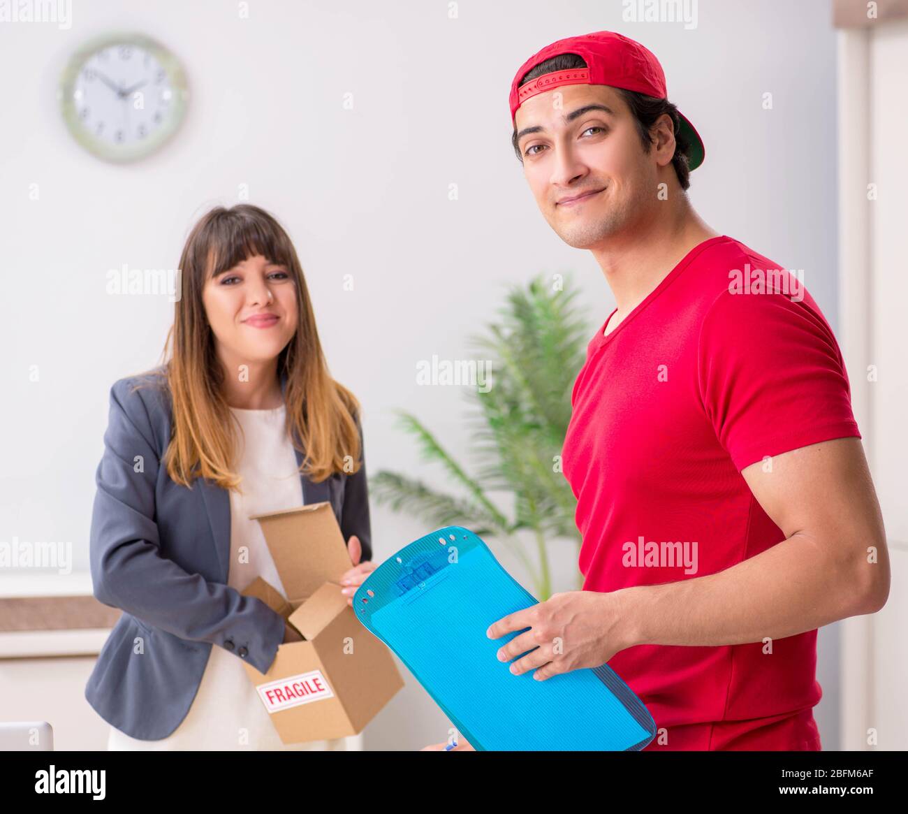 The courier delivering parcel to the office Stock Photo - Alamy