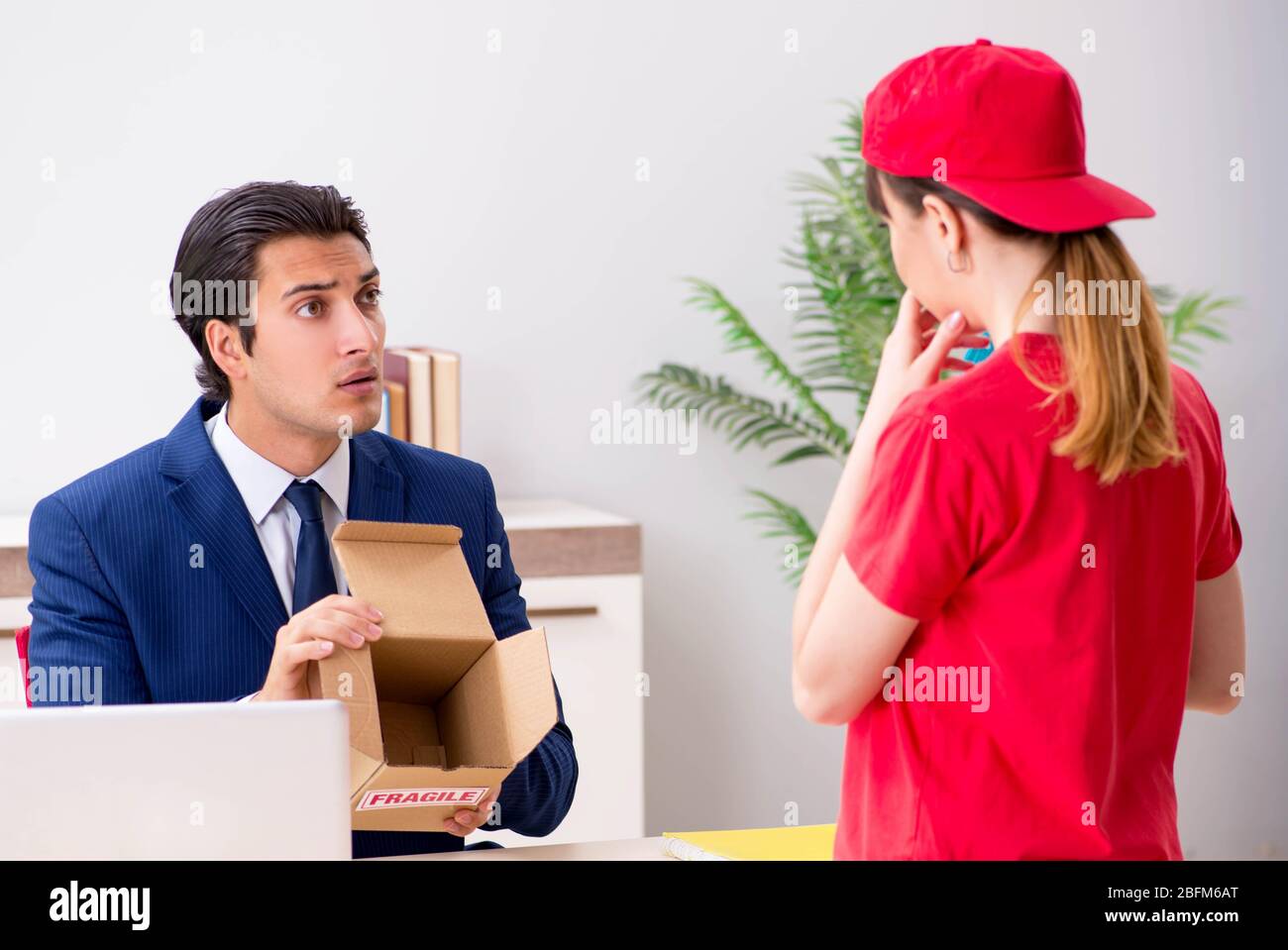 The courier delivering parcel to the office Stock Photo - Alamy