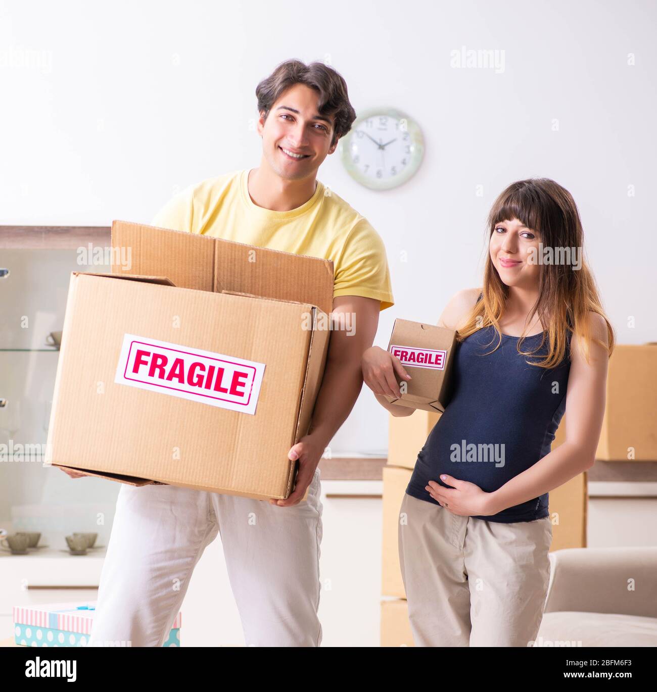 The young couple moving to new flat with fragile things Stock Photo - Alamy