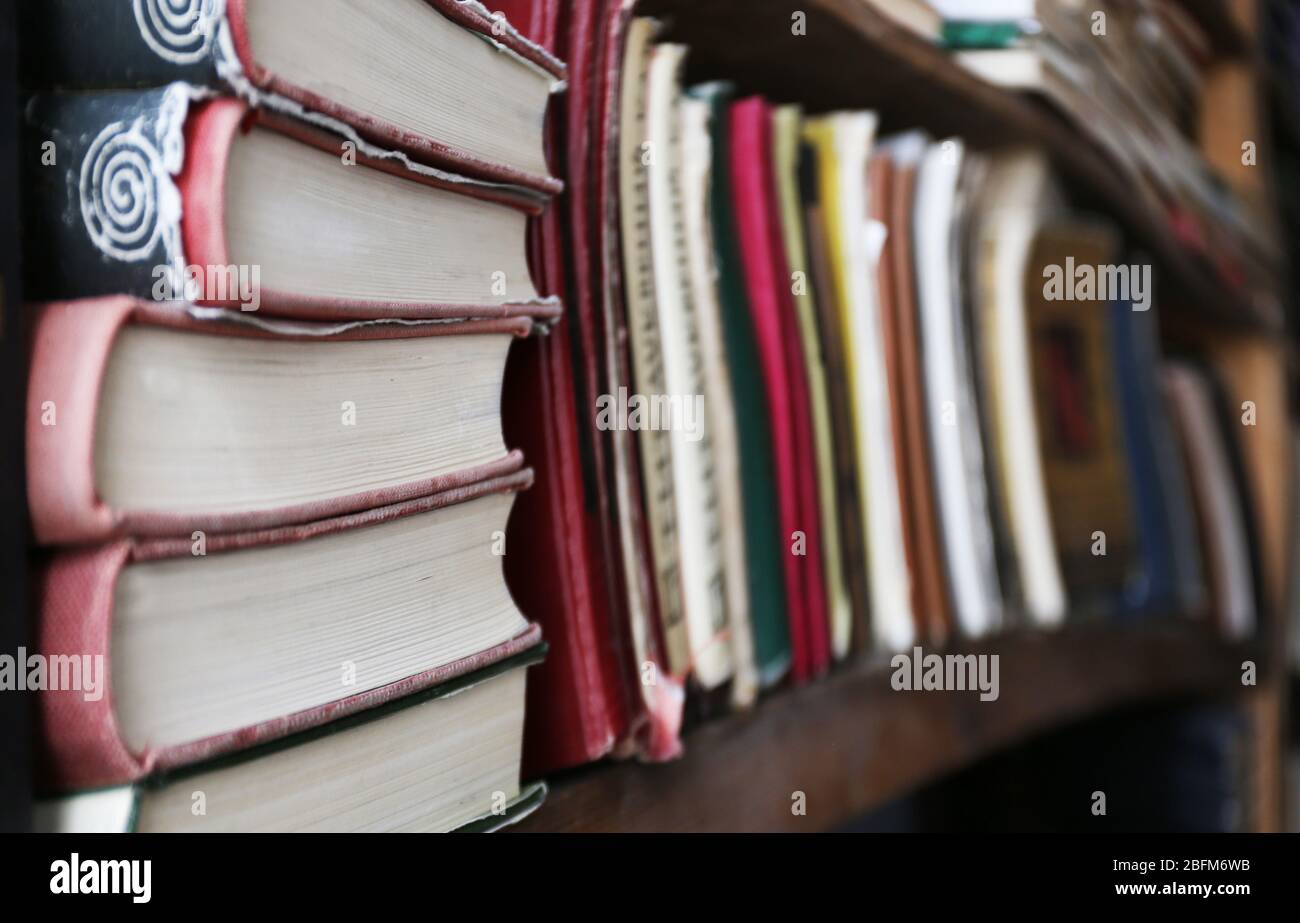 Many books on bookshelf in library, image with perspective distortion ...