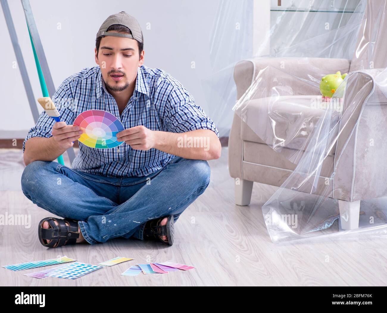 The young man contractor choosing color from rainbow Stock Photo - Alamy