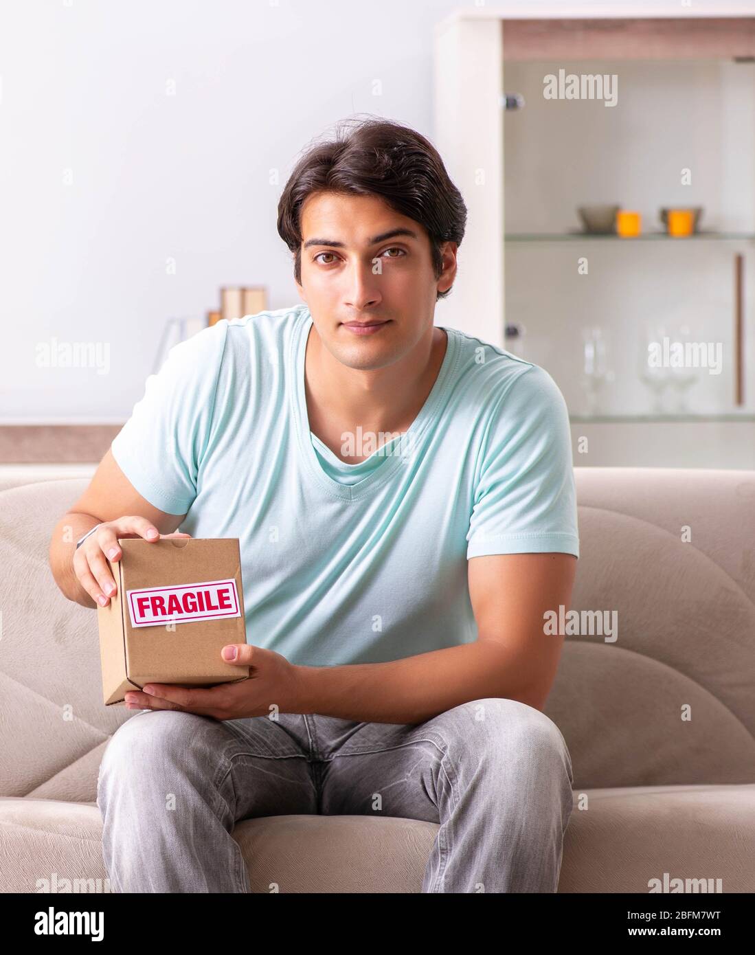 The man opening fragile parcel ordered from internet Stock Photo - Alamy