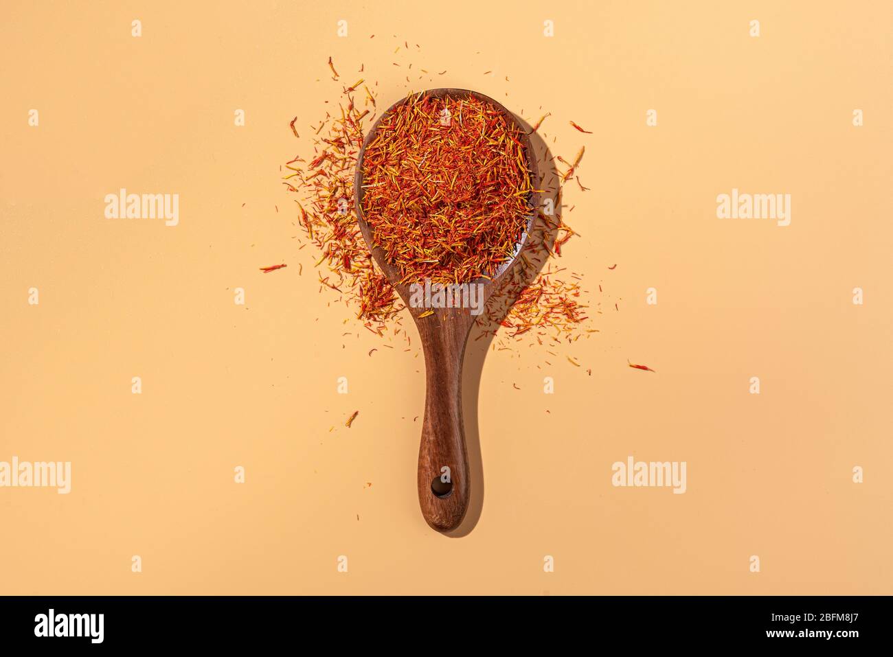 The strings of the leaves of saffron in wooden spoon on a beige ...