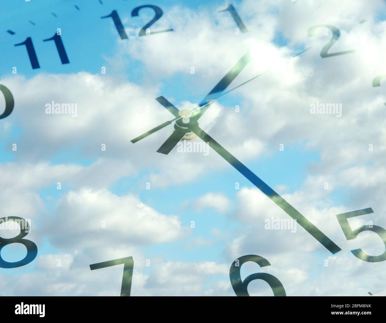 Clock face in bright sky Stock Photo - Alamy