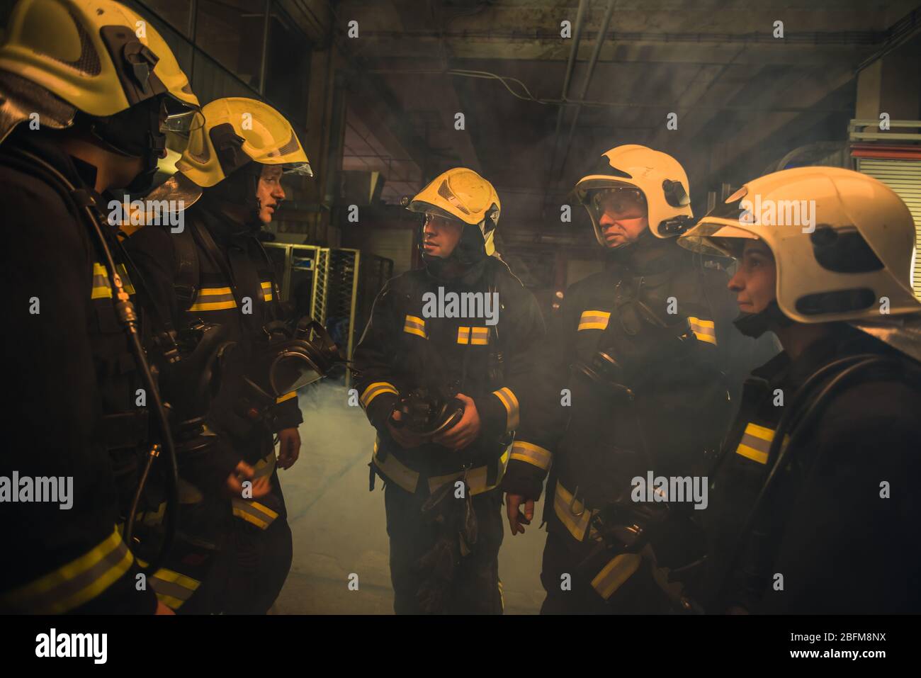 Group of firefighters with uniform inside the fire station preparing ...