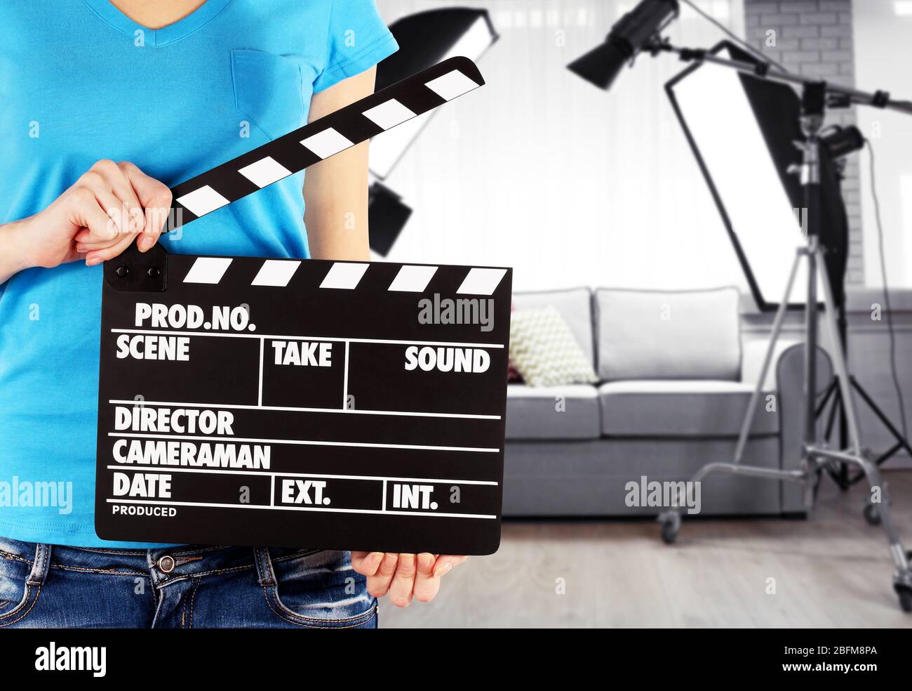 Operator holding clapperboard during the production of film indoors ...