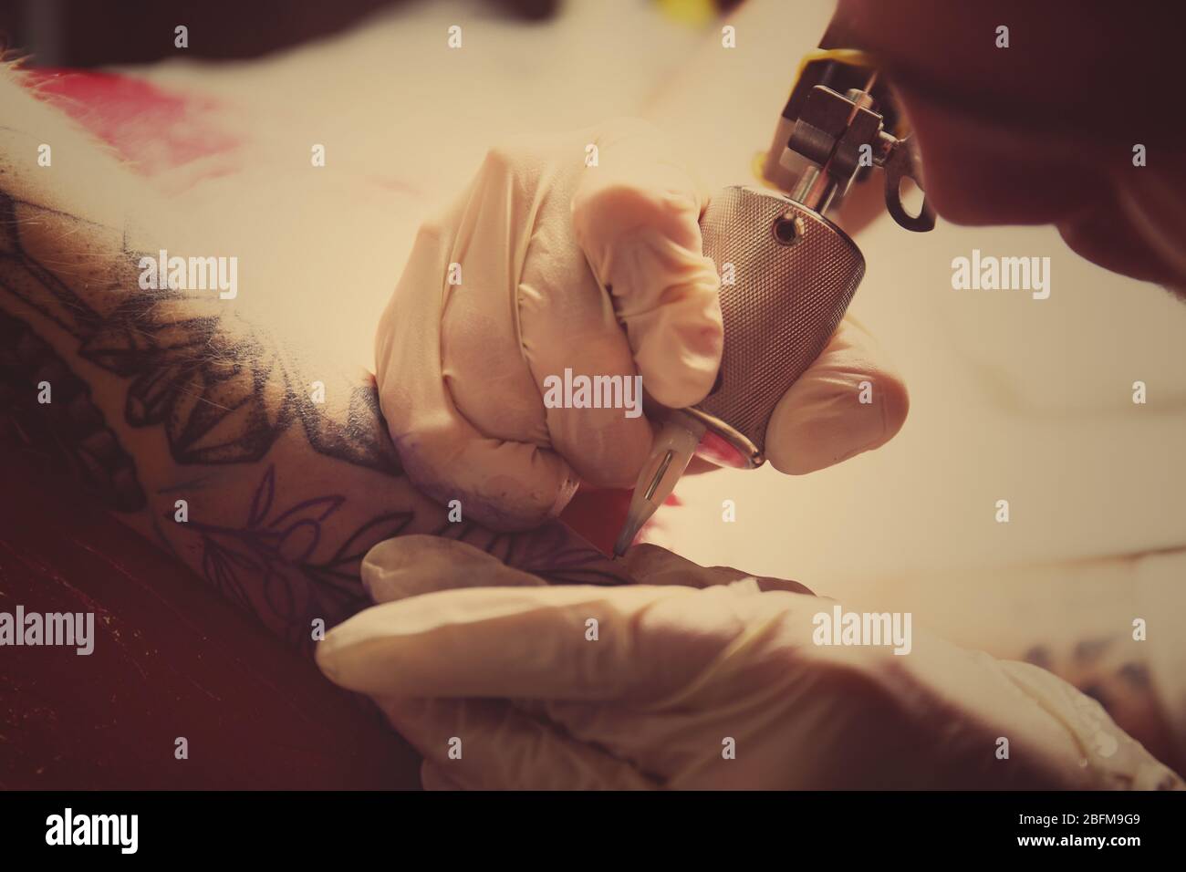 Professional tattoo artist doing tattoo, close up Stock Photo - Alamy