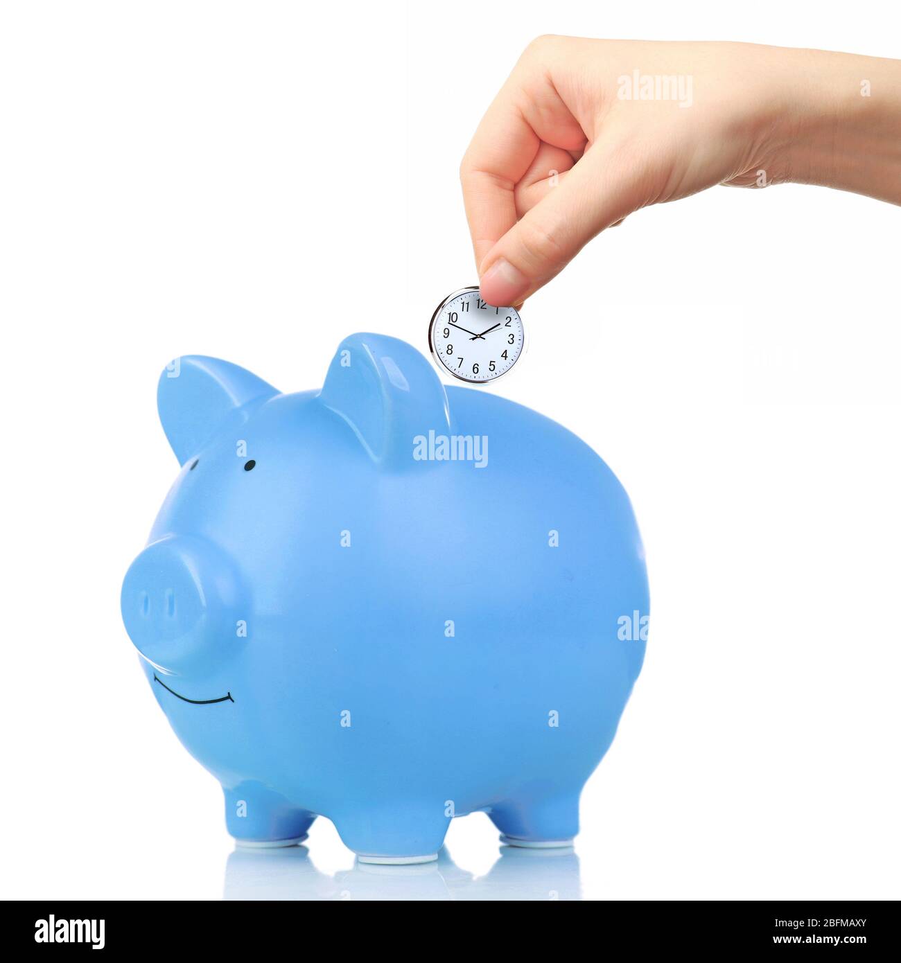 Time is money concept. Hand depositing coin with clock dial in piggy ...