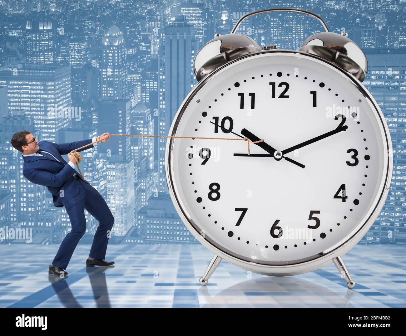 The businessman pulling clock in time management concept Stock Photo ...