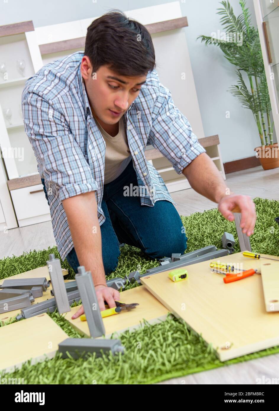 The man assembling furniture at home Stock Photo - Alamy