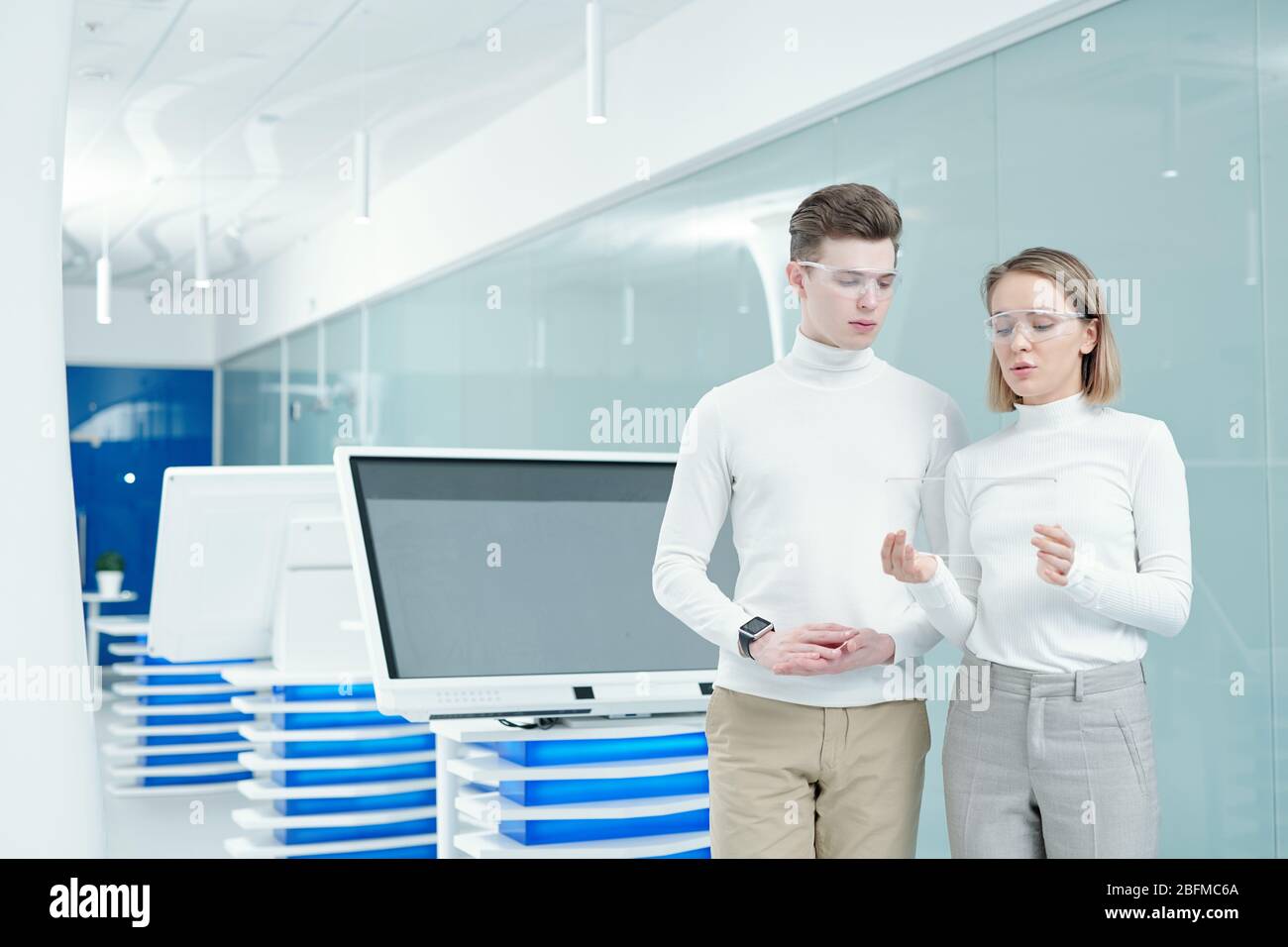 Blond young female office manager consulting client about new ...