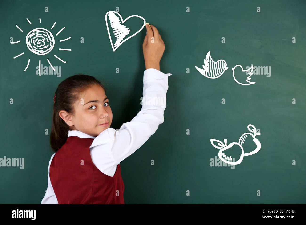 Beautiful little girl drawing on blackboard in classroom Stock Photo ...