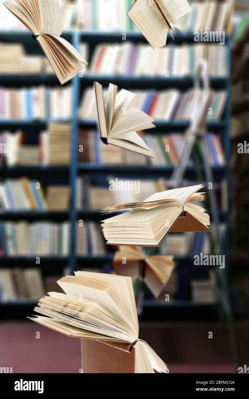 Flying books on library bookshelves background Stock Photo - Alamy