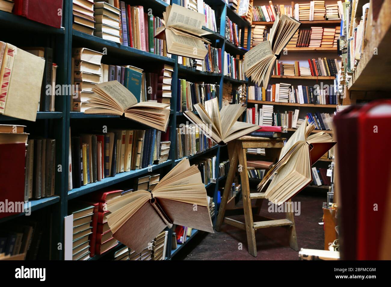 Flying books on library bookshelves background Stock Photo - Alamy