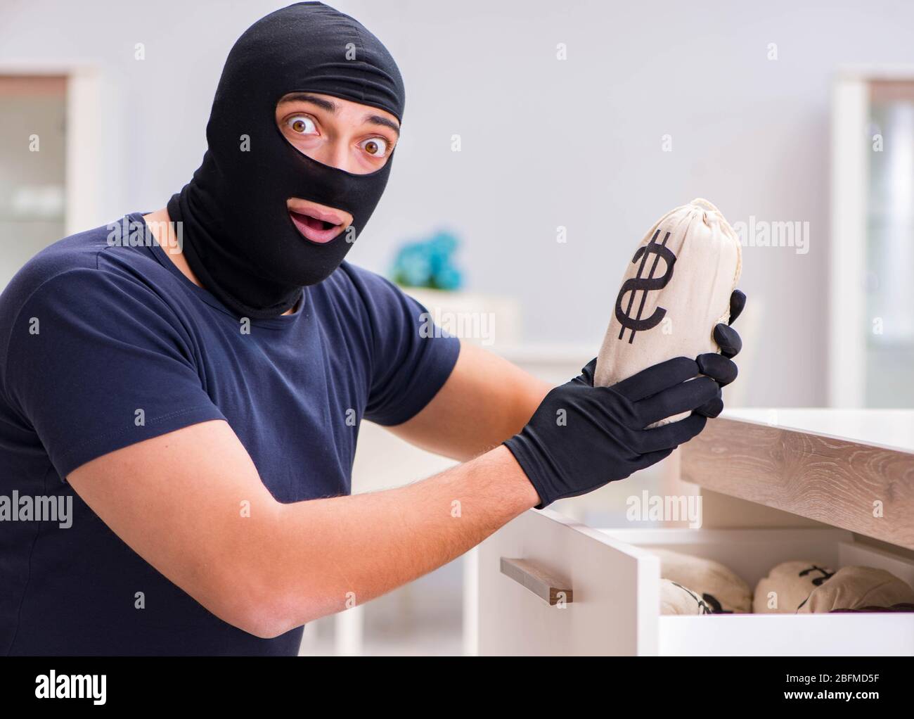 The robber wearing balaclava stealing valuable things Stock Photo - Alamy