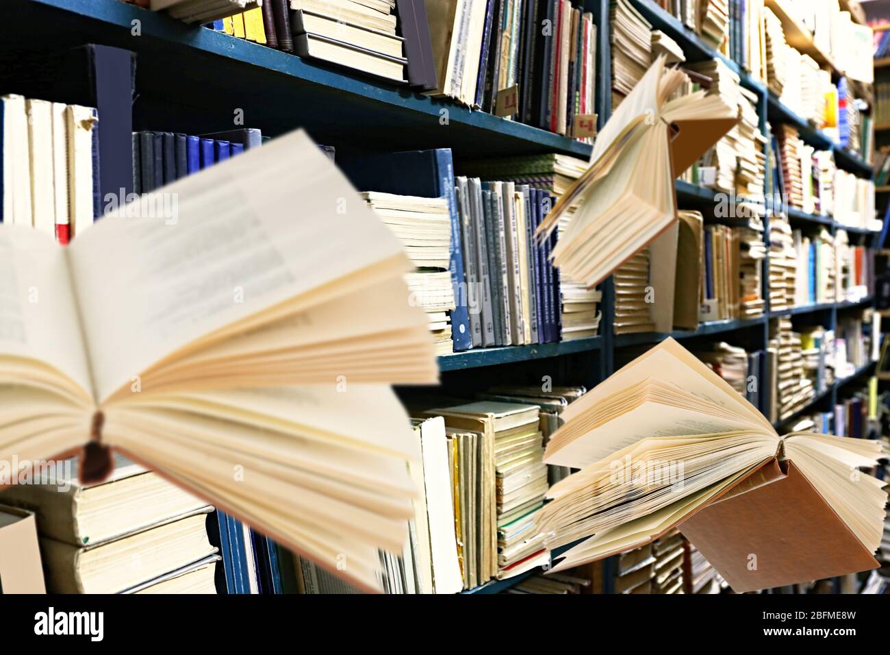 Flying books on library bookshelves background Stock Photo - Alamy
