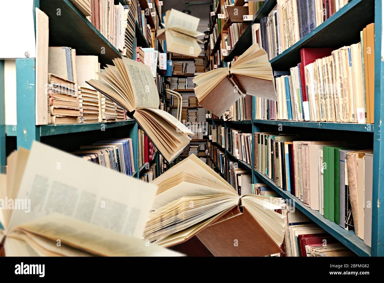 Flying books on library bookshelves background Stock Photo - Alamy
