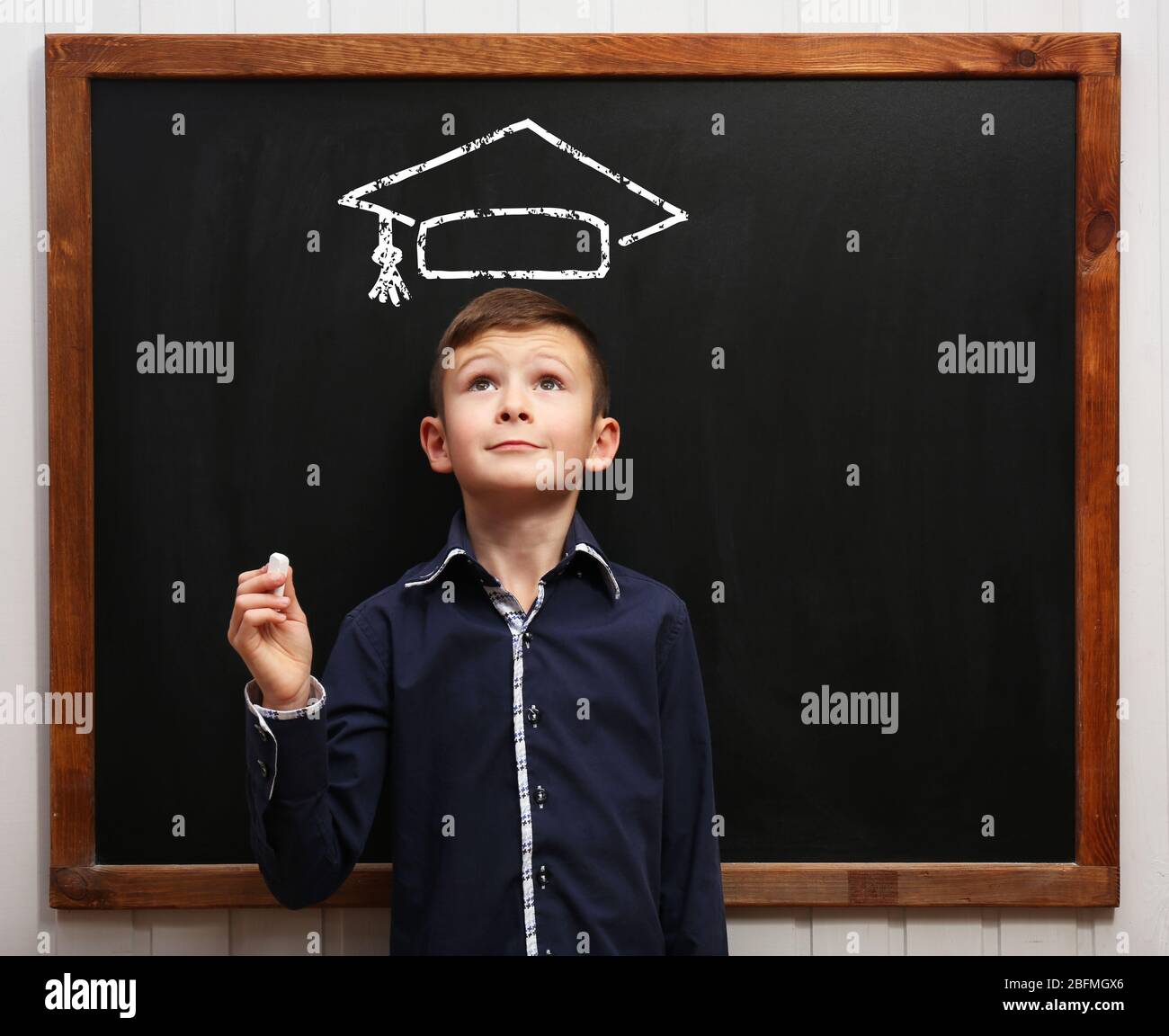 Cute boy posing at the blackboard, in the classroom Stock Photo - Alamy