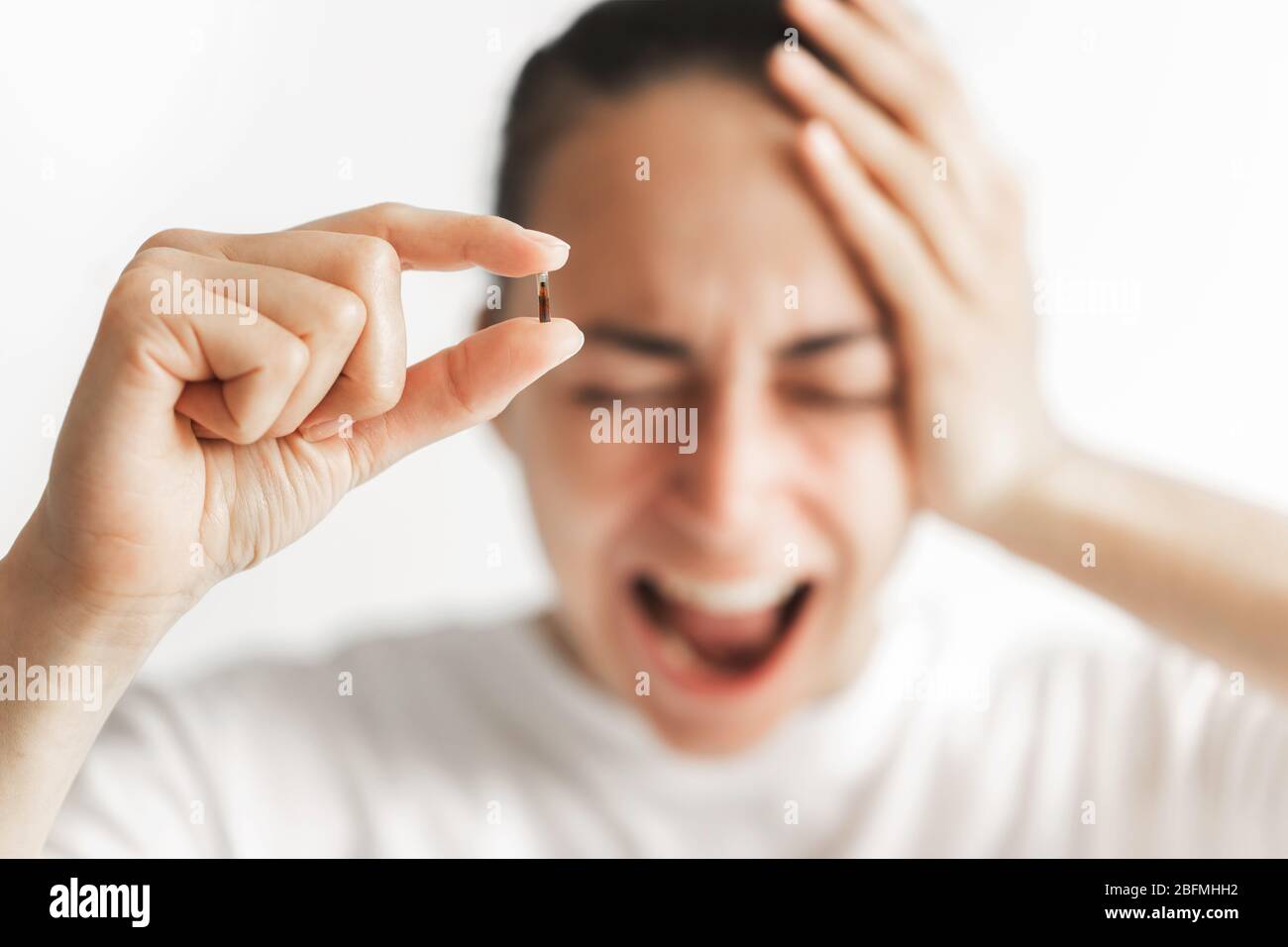 Person holding in fingers micro chip for implantation with defocused ...
