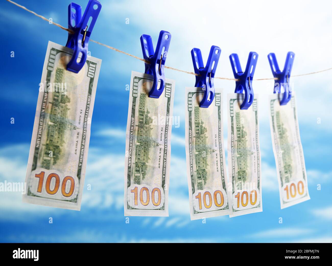Concept of money laundering - dollars are drying on cord on sky ...