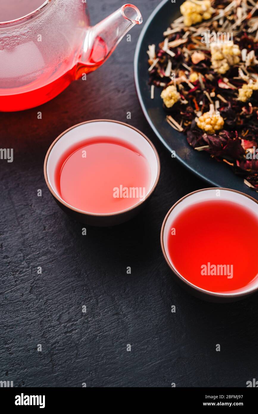 Aromatic fresh brew natural red fruit tea in two bowls ,glass teapot ...