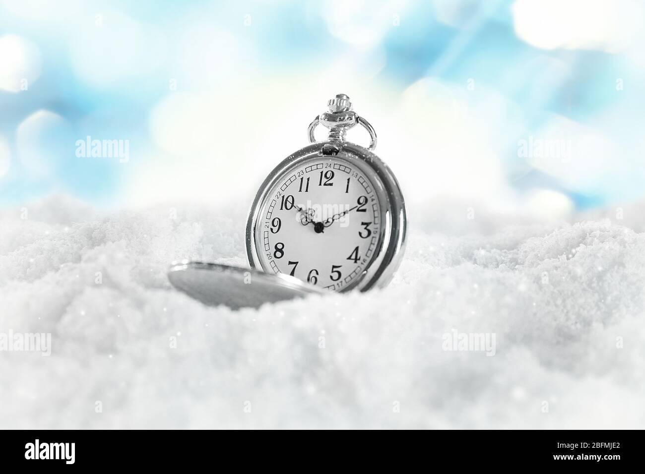 Pocket watch over white snow background Stock Photo - Alamy