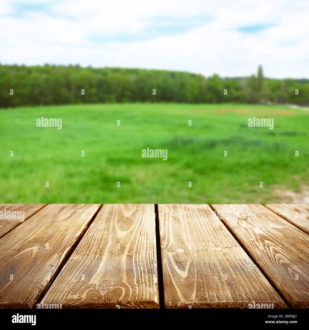 Wooden table on blurred nature background Stock Photo - Alamy