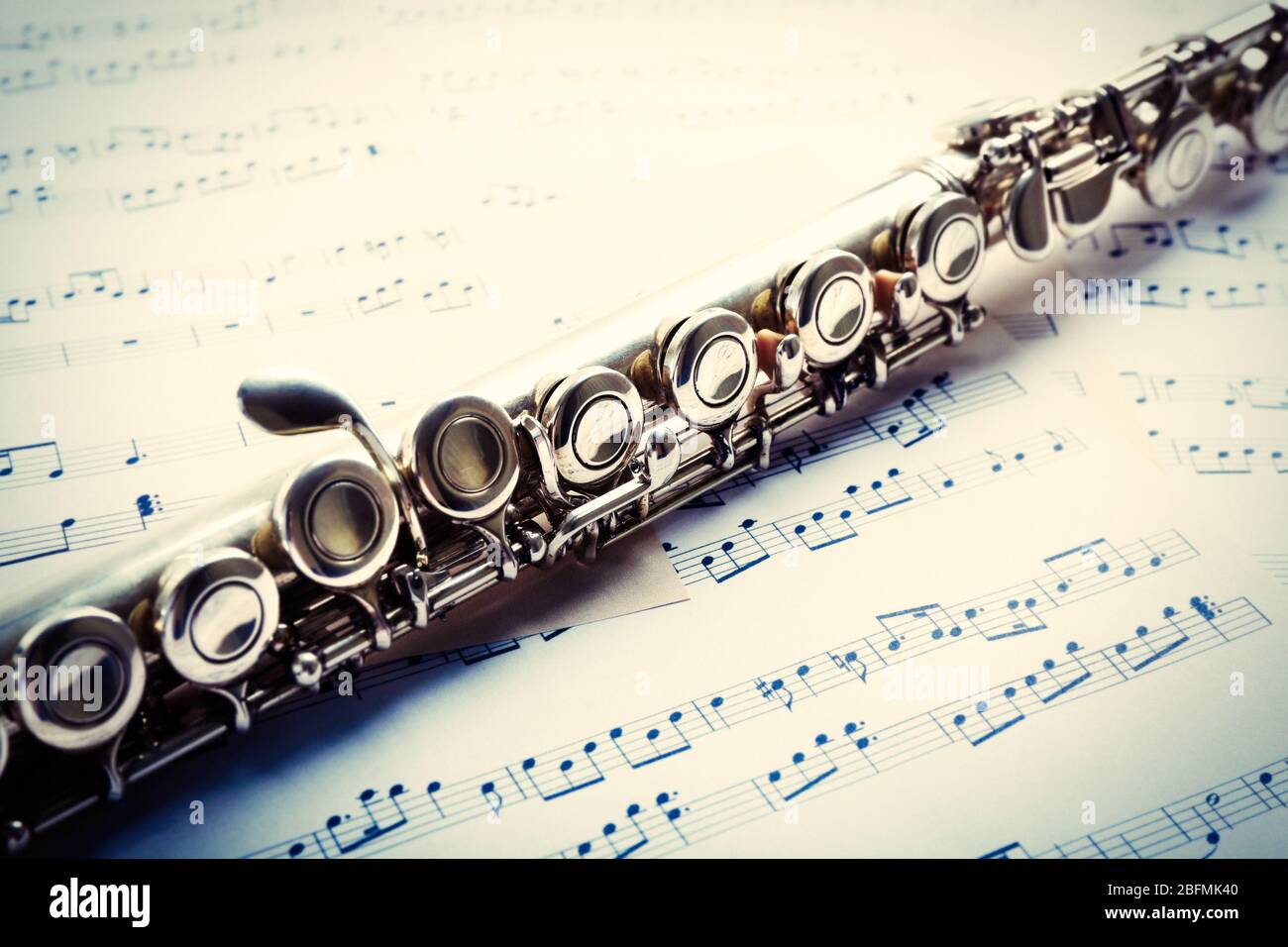Flute on musical notes background Stock Photo - Alamy