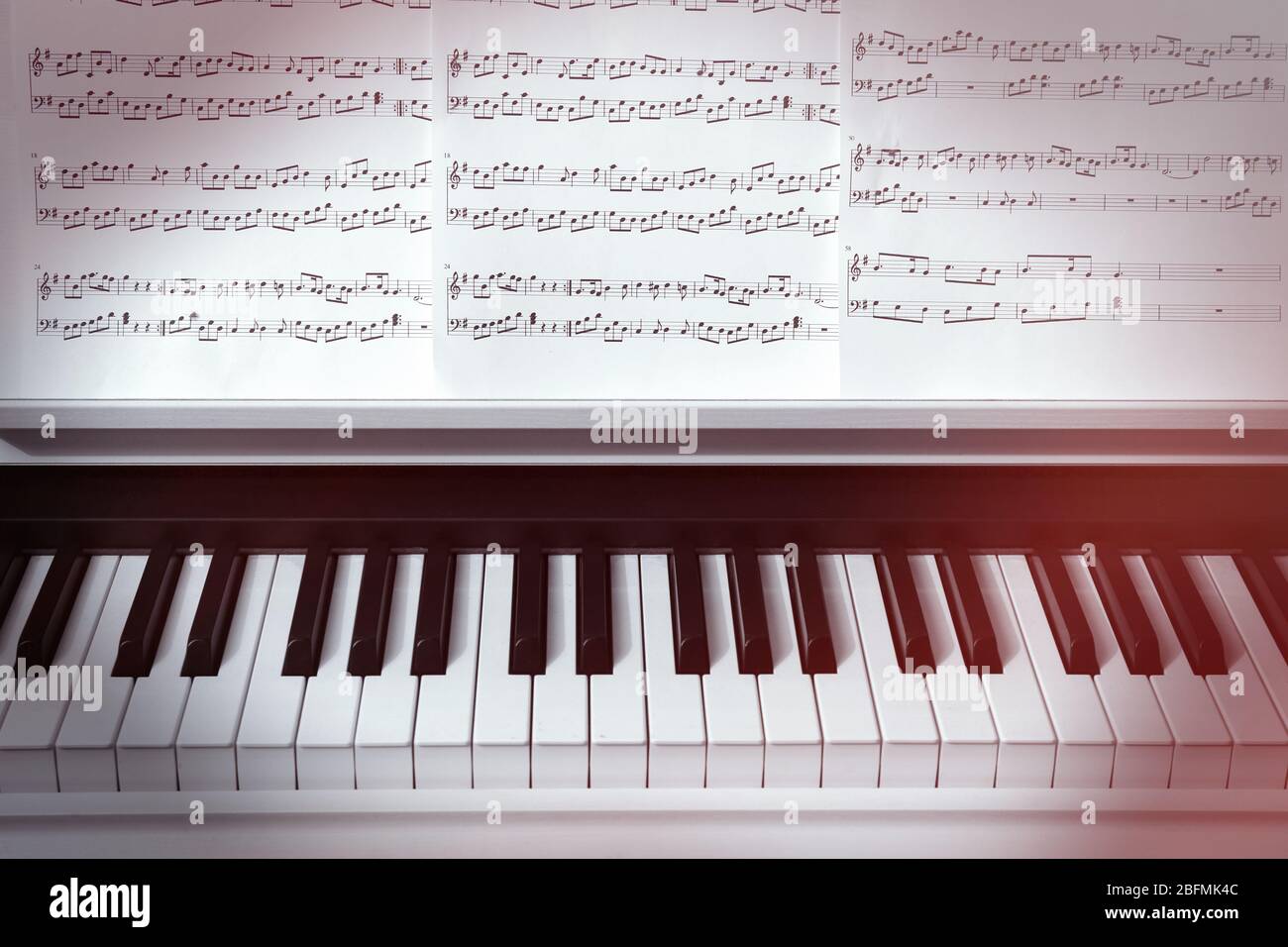 Piano keyboard and musical notes close up Stock Photo - Alamy