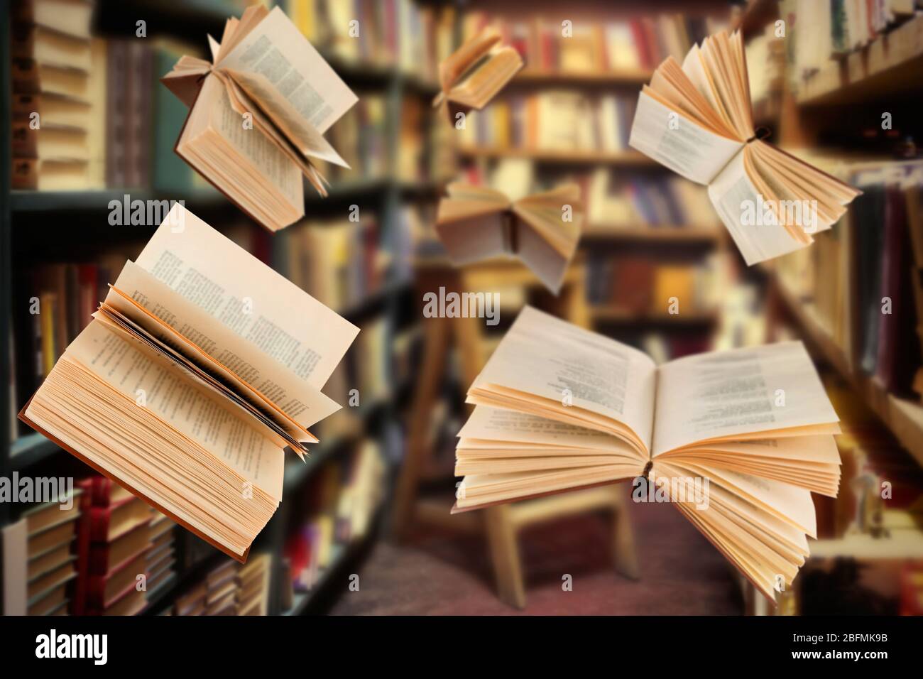 Flying open books in library Stock Photo - Alamy