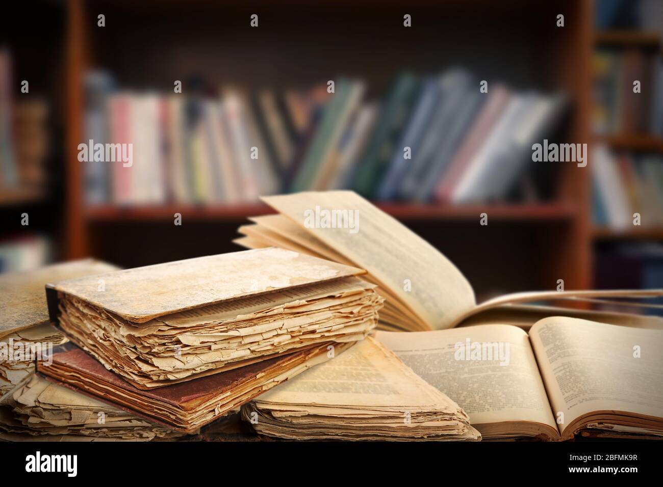 Pile of open books in library Stock Photo - Alamy