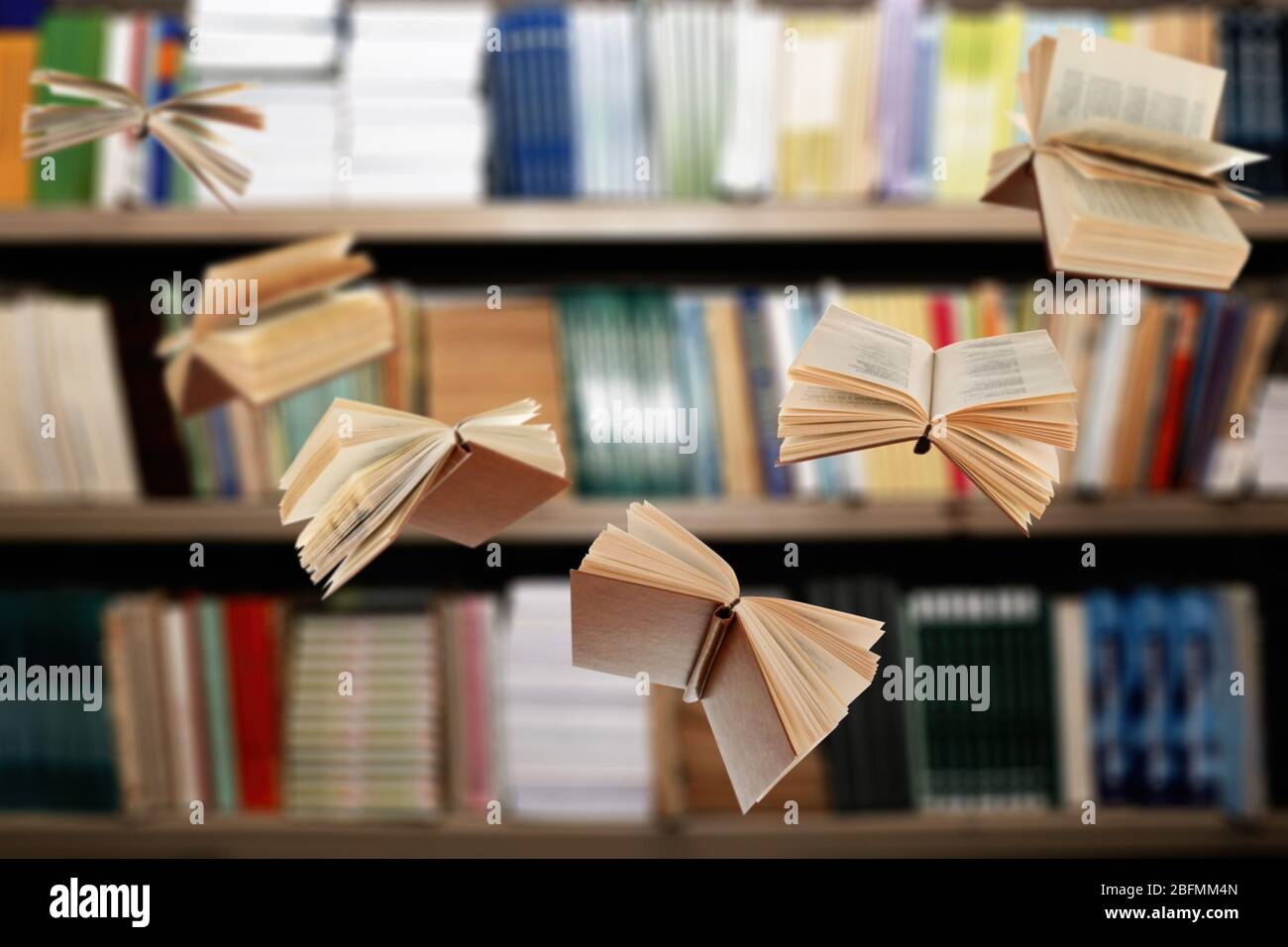 Flying open books in library Stock Photo - Alamy