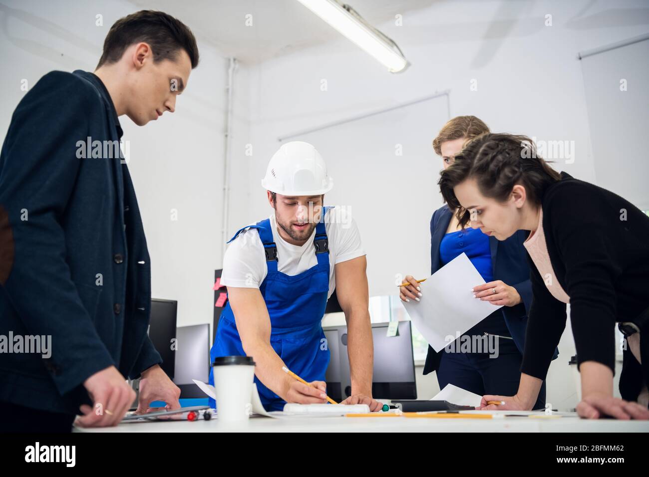 Engineers discussing the efficiency of the construction plan in their ...