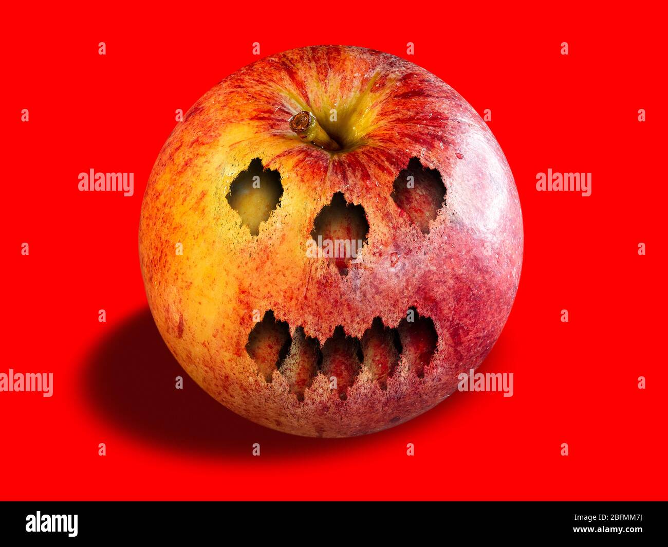 Apple with evil face Stock Photo - Alamy