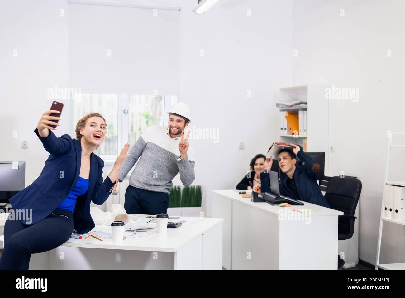 Employees having fun in the office, posing, making funny faces and ...
